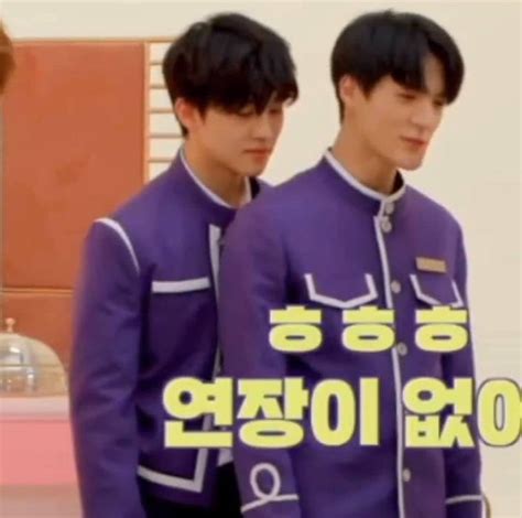 Two Young Men Standing Next To Each Other In Front Of A Tv Screen With