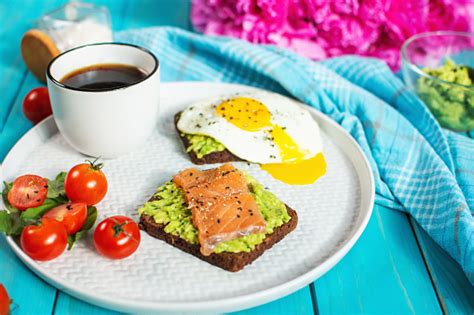 튀긴 계란 아보카도 소금에 절인 연어를 곁들인 샌드위치와 아침 식사를 위해 향기로운 커피 한 잔 과일에 대한 스톡 사진 및 기타 이미지 Istock