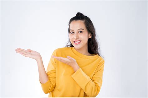 젊은 행복한 아시아 여자 가리키는 보여주는 손을 보여주는 프리젠 테이션 에 복사 공간 그녀 입고 노란색 스웨터 셔츠 촬영 에