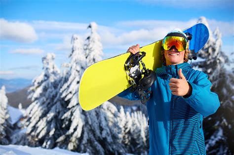 스노 스키 리조트 숲 근처에서 어깨에 들고 스노우보드 Freeride 세션 전에 포즈 웃 고 입고 등록 엄지손가락을 보여주는