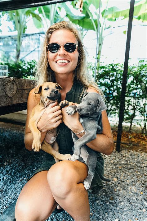 Woman Hugging Two Cute Puppies By Stocksy Contributor Andrey Pavlov