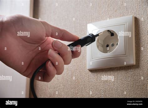 A Female Hand Inserts An Electric Plug Into A Euro Format Socket Close Up Stock Photo Alamy