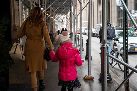 мама и милая дочь держатся за руки под лесами Nyc Редакционное Стоковое Изображение