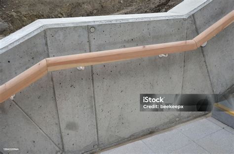 손잡이 의 바닥에서 노란색 빛이있는 오목한 Led 스트립입니다 숨겨진 내장 램프는 남자의 손을 보여줍니다 옹벽이 있는 계단의