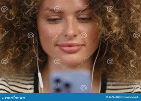 Close Up Portrait Of Beautiful Curly Woman Listening To Podcast In