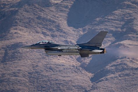 F16 네바다 언덕에 대한 팔콘 싸움 날개에 미사일과 항공기 뒤에 보이는 제트 스트림 군용 항공기에 대한 스톡 사진 및 기타