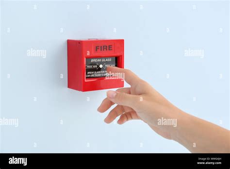 Woman Using Manual Call Point Of Fire Alarm System Stock Photo Alamy