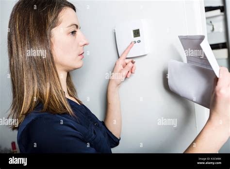 Woman Set The Thermostat At Home Stock Photo Alamy