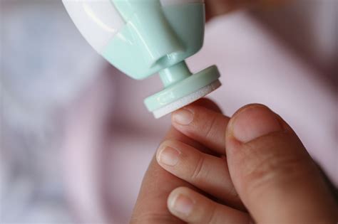 네일 파일로 손톱을 잘라 어머니는 자동 아기 손톱 파일 기계를 사용 하 여 아기 손톱을 작성 합니다 가위에 대한 스톡 사진 및