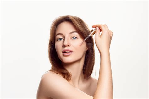 얼굴 세럼을 바르는 건강하고 흠 없고 맑은 피부로 아름답고 흰색 배경에 피부 컨디션을 관리하세요 눈 신체 부분에 대한 스톡 사진 및 기타 이미지 Istock