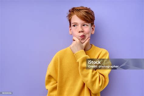 어리둥절한 표정을 짓고 있는 영리한 빨간 머리 학생 옆을 보며 생각하고 있습니다 아이에 대한 스톡 사진 및 기타 이미지 아이