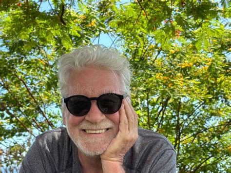 Attractive Smiling Senior Man Lying Down In The Grass In The Park