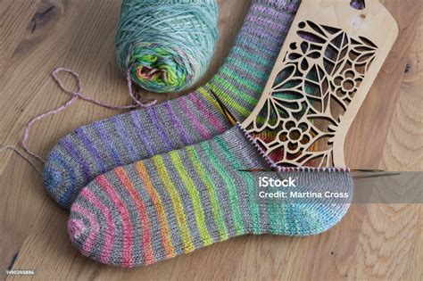 나무 배경의 바늘에 뜨겁게 달궈진 멋진 무지개 줄무늬 패턴이 있는 아름다운 손으로 짠 양말 한 켤레 0명에 대한 스톡 사진 및 기타 이미지 Istock