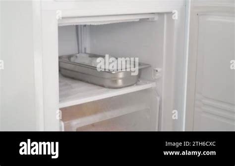 A Man Takes Ice Cubes From The Freezer Or Puts Them In A Glass For A