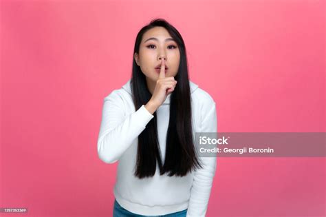 입술에 손가락을 들고 예쁜 젊은 아시아 소녀는 침묵을 보여줍니다 비밀을 유지하도록 요청 사생활 독특한 판매 제공 20 29세에