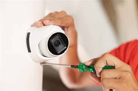 집에서 벽에 Cctv 카메라를 고정하는 기술자의 클로즈업 샷 안전 전문 작업자 및 유지 보수 서비스의 개념 설치에 대한 스톡