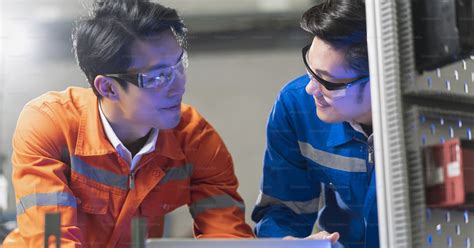 남성 아시아 엔지니어 전문가는 공장에서 기계 옆에 서서 토론을 하고 두 명의 아시아 동료가 기계의 프로세스 Curcuit 마더 보드를 설명하고 해결합니다 사진