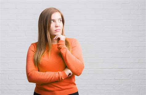 질문 매우 혼란 스 러 워 아이디어에 대해 흰색 벽돌 벽 심각한 얼굴 생각에 젊은 성인 여자 가을에 대한 스톡 사진 및 기타