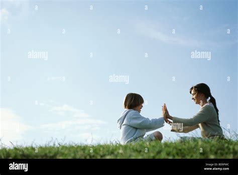 Brother And Sister Playing Clapping Game Outdoors Stock Photo Alamy
