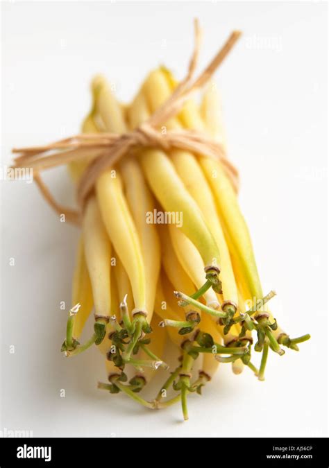 A Bunch Of Ripe Yellow French Beans Tied Up With String On A White