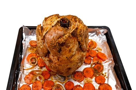 오픈 맥주 병에 박제 된 생 닭은 당근과 양파가있는 트레이에 누워 오븐에서 베이킹을 준비했으며 흰색 배경에 클리핑 경로가 있습니다 0명에 대한 스톡 사진 및 기타 이미지