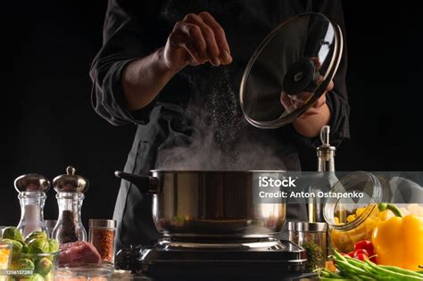 요리 전문가 또는 요리사가 드레싱에서 수프 또는 이탈리아 파스타를 요리합니다 야채의 배경에 대해 증기로 팬을 가열합니다 레시피