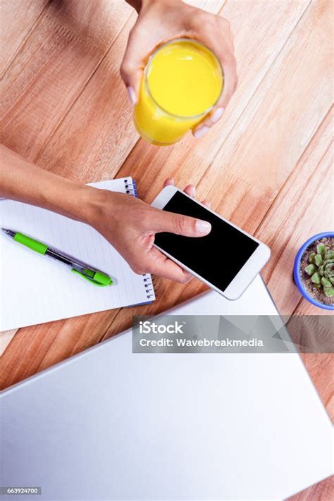 스마트폰과 오렌지 주스의 유리를 들고 있는 여성용 손의 오버헤드 낮에 대한 스톡 사진 및 기타 이미지 낮 노트북 만짐 Istock