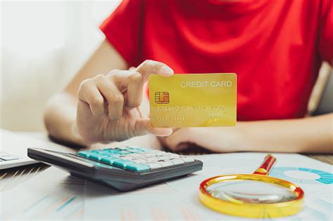 한 손에 신용카드를 들고 계산기를 사용하며 테이블 위에서 금융 문서를 검토하는 사람 장면은 재무 관리 및 계획의 감각을 전달합니다 0명에 대한 스톡 사진 및 기타 이미지