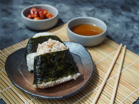 오니기리 일본 전통 음식 찐 쌀은 김으로 감싼 삼각형 모양입니다 프리미엄 사진