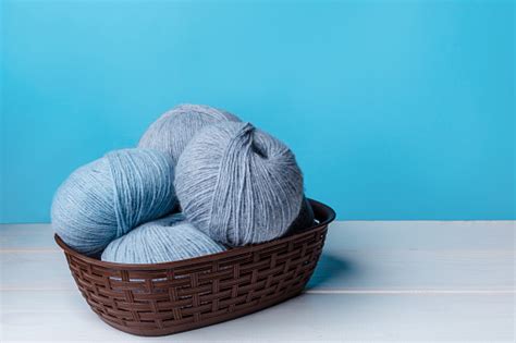 파란색 배경흰색 보드에 실의 모직 Skeins 이탈리아 앙고라에서 스레드의 공 뜨개질 프로젝트가 진행 중입니다 원사와 뜨개질