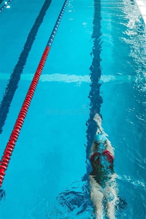 Top View Of A Young Female Swimmer Training In The Pool Swimming On