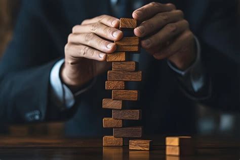 Businessman Stacking Wooden Blocks In A Tower Concept Of Strategy Risk