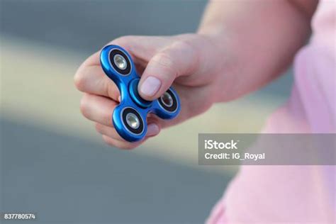회색 배경 스트레스와 이완 Fidgets 안티 불안 구제 장난감 인기 있는 피 젯 회전자 장난감을 들고 거리 여성 손에 손에