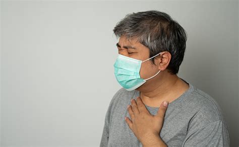 아픈 아시아 남자는 의료 얼굴 마스크를 착용하고 기침과 내 손으로 입을 덮고 보호 전염병 코로나바이러스 및 호흡기 질환의 개념