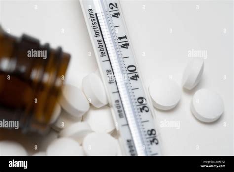 Mercury In Glass Thermometer On White Surface With Medicine And Pills