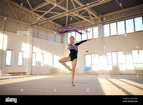 Rhythmic Gymnast In Black Leotard With Ribbon Performing Gymnastics