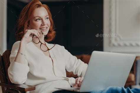 Horizontal Shot Of Thoughtful Young Redhead Woman Concentrated