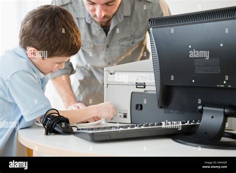 Father And Son Setting Up Printer With Computer On Table Stock Photo Alamy