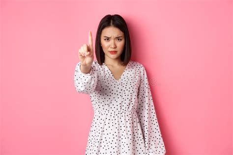 Serious And Angry Asian Woman Telling To Stop Frowning And Showing