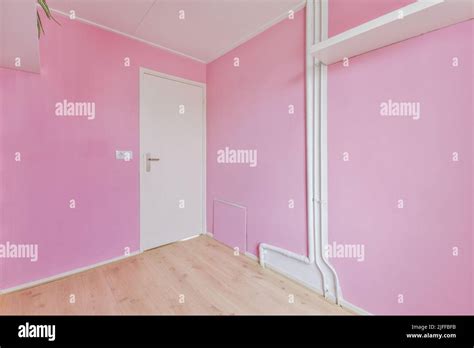 Spacious Empty Room With Pink Walls And White Pipes Shelf And Door