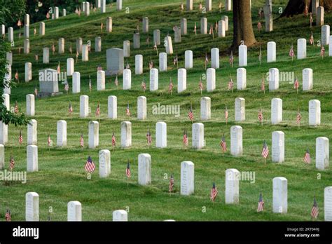 Soldiers Place Flags On Graves At Arlington National Cemetery Stock