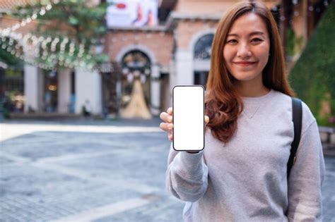 Premium Photo Woman Holding And Showing A Mobile Phone With Blank White Screen While Traveling