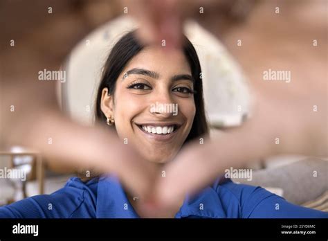 Cheerful Young Indian Woman Making Love Symbol With Joined Fingers