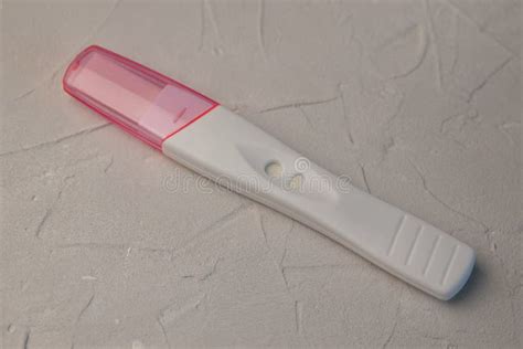 White Pregnancy Test With Pink Cover On Grey Concrete Background Stock