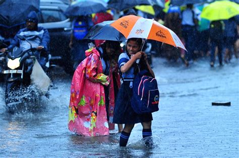Mumbai School Students Hold Umbrellas Wade Through A Waterlogged Road