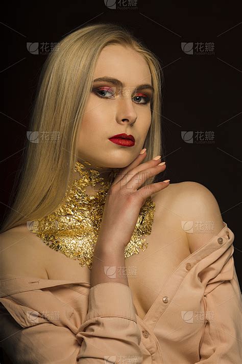 漂亮的年轻女人，化着完美的妆，脖子上戴着金箔