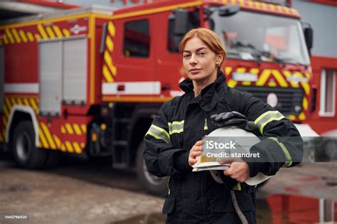 뒤에 대형 트럭 보호 헬멧을 들고 제복을 입은 여성 소방관이 부서에서 일하고 있다 소방관에 대한 스톡 사진 및 기타 이미지 소방관 여자 한 명의 여자만 Istock
