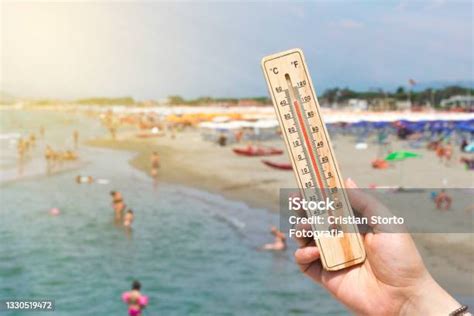 Wanita Memegang Termometer Di Depan Pantai Italia Yang Ramai Foto Stok