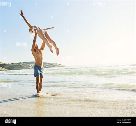 Bring On The Beach Days A Young Man Lifting His Girlfriend Up Into The Air At The Beach Stock