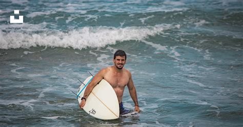 서핑보드를 들고 바다에서 걸어 나오는 남자 사진 Unsplash의 무료 자연 이미지